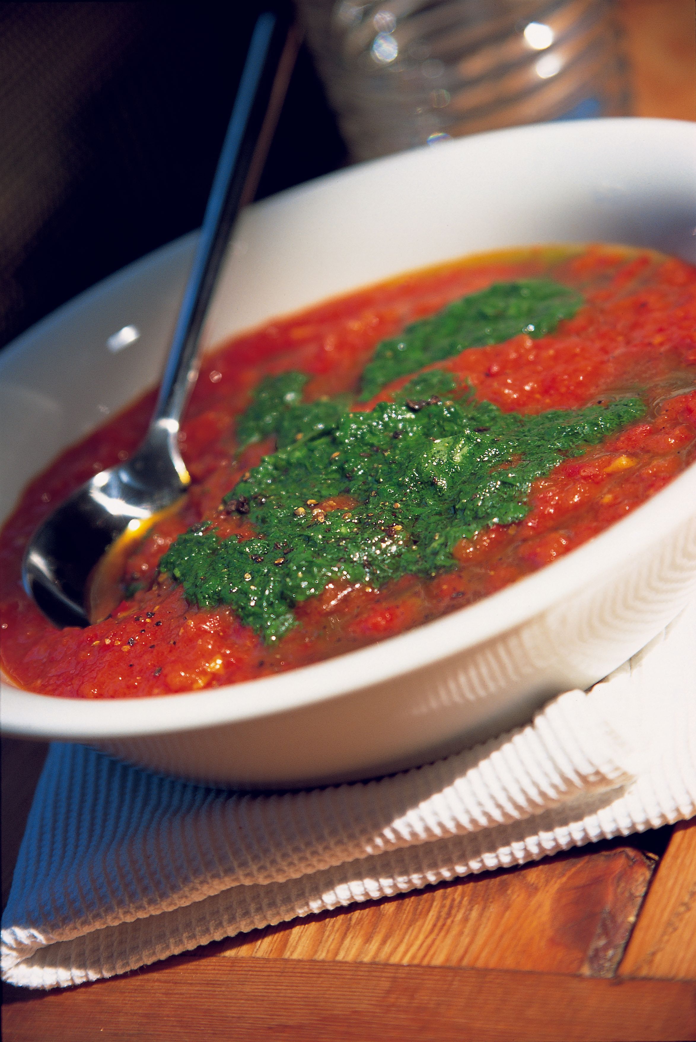 Fresh tomato and sweet chilli pepper soup with smashed basil and olive oil