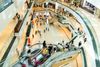 People ride an escalator in an indoor mall.
