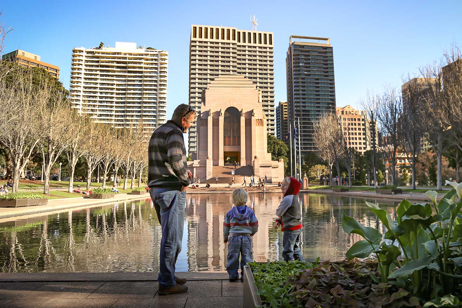 Two children and a parent in a park.