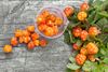 A transparent bucket of Cloudberries.