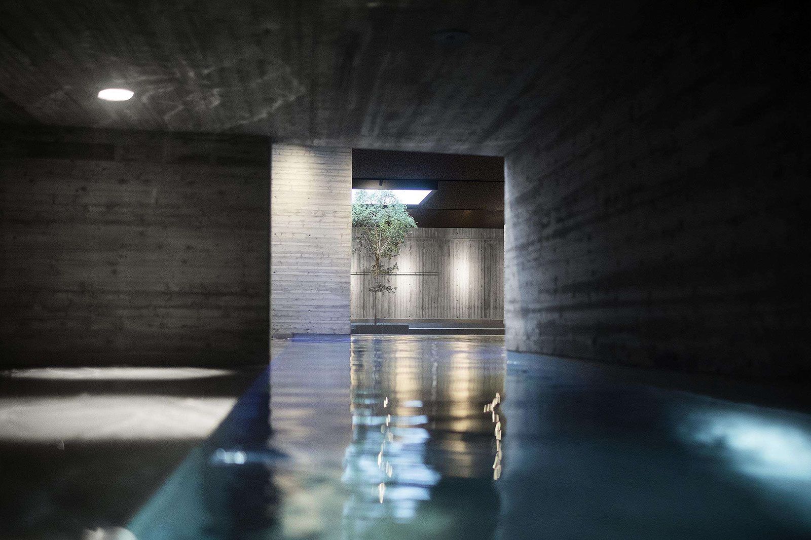 A reflection of water in a grey walled indoor spa.