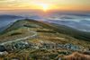 A sunrise in mountains along a hiking trail.