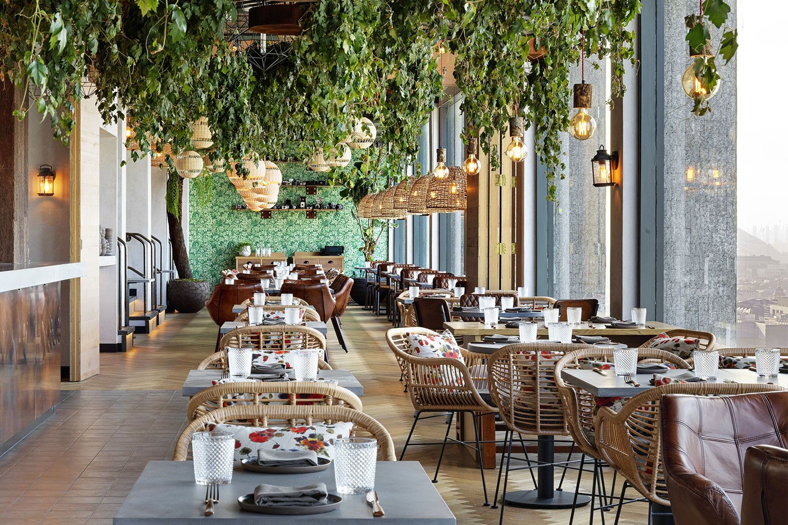 A dining seating area with plants and lights.