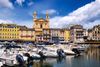 A church building in a port with boats.