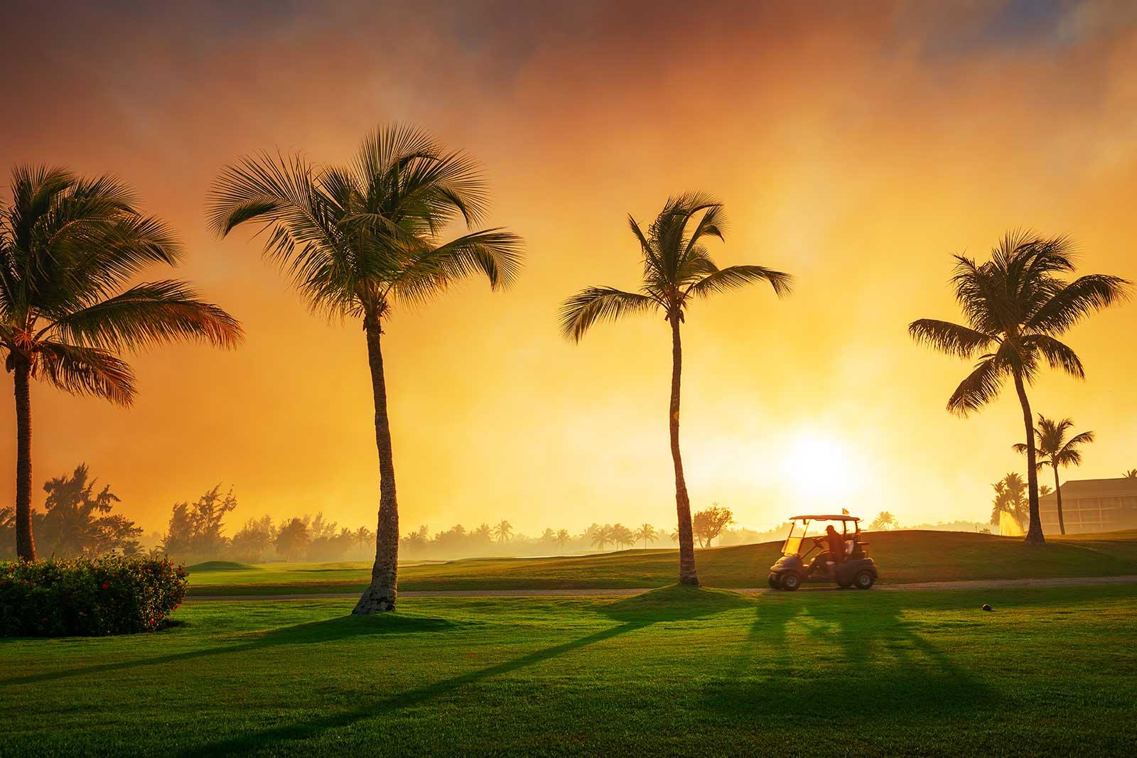 A golf cart on a sunny golf course.