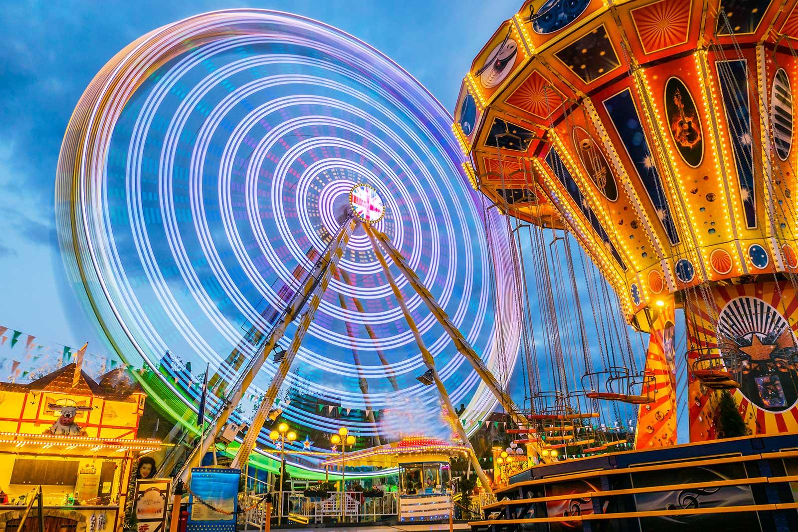 A view of a fair ground with a Ferris wheel and carousel.