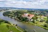 A view from a drone of the a large castle along a river.