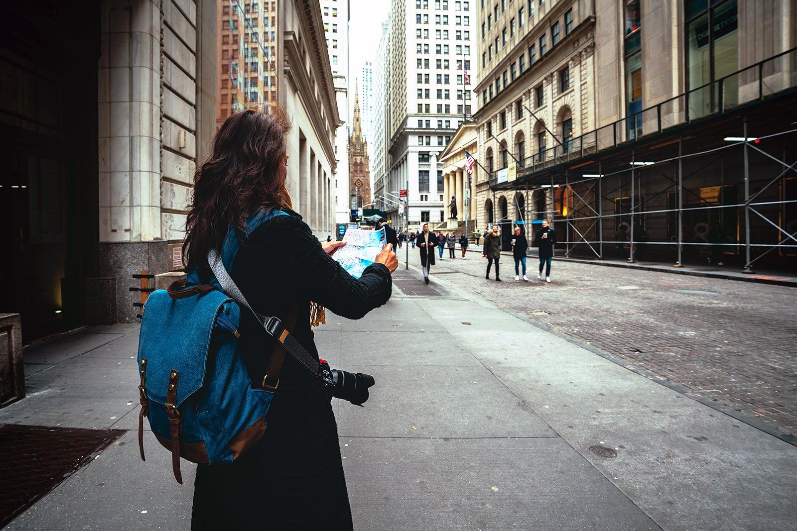 A person with a map on a street.