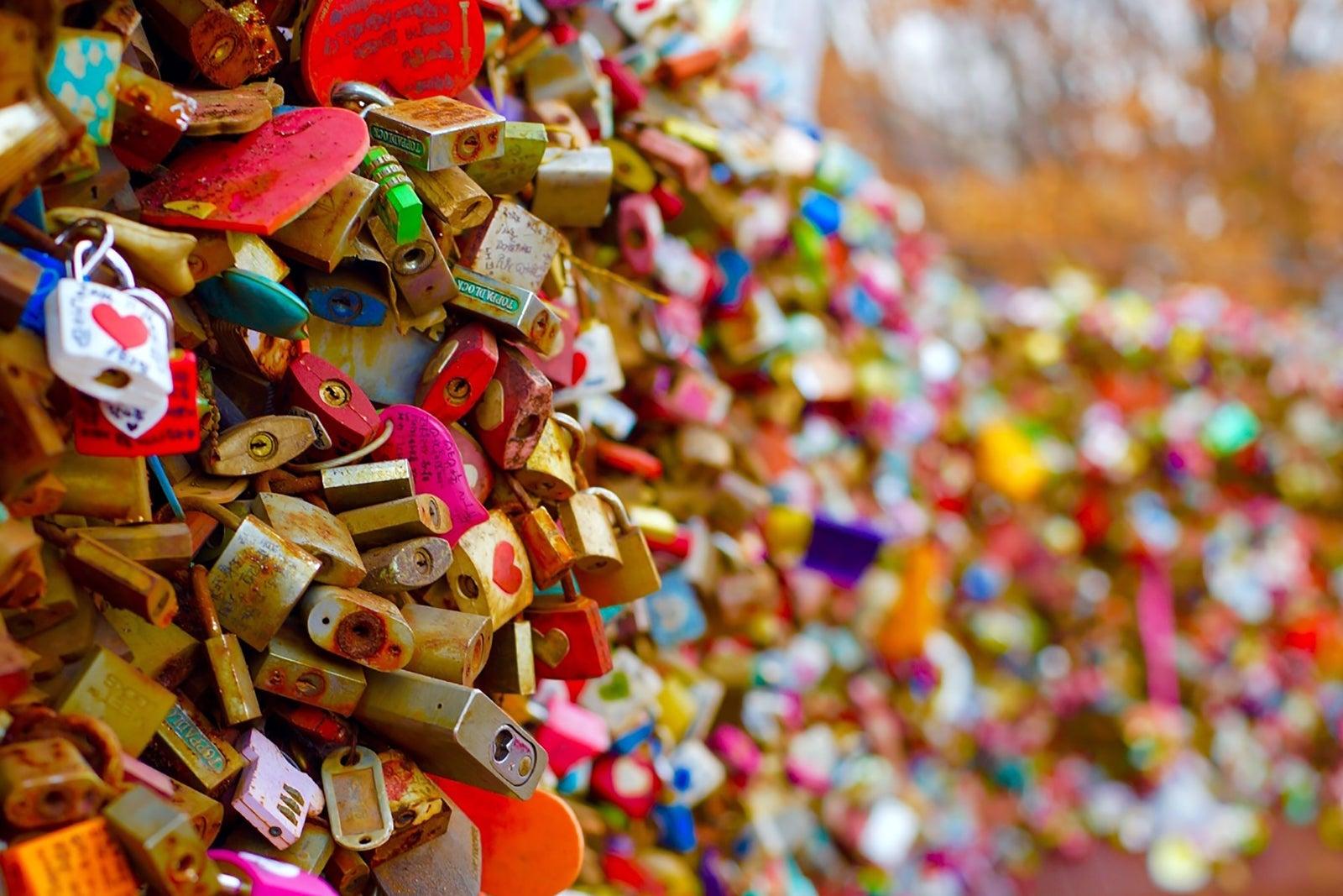 Thousands of padlocks painted with hearts, attached to a wall or fence