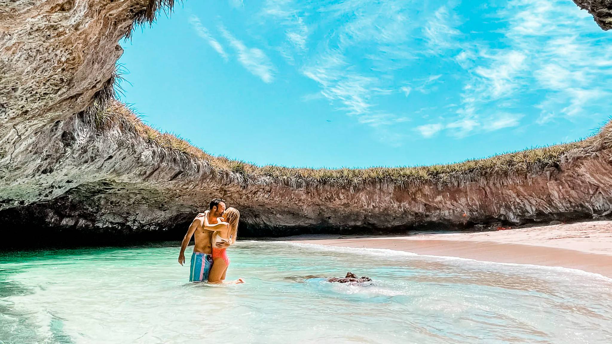 A couple embraces in the clear waters of Hidden Beach, Marietas Islands.